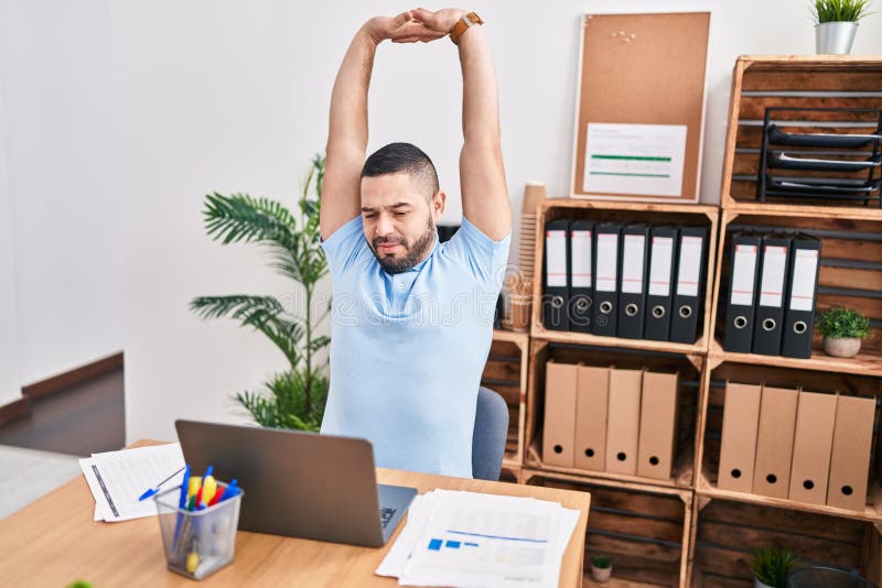 Young Latin Man Business Worker Using Laptop Stretching Arms at Office ...