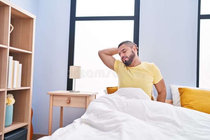 Young Latin Man Waking Up Stretching Arms at Bedroom Stock Image ...