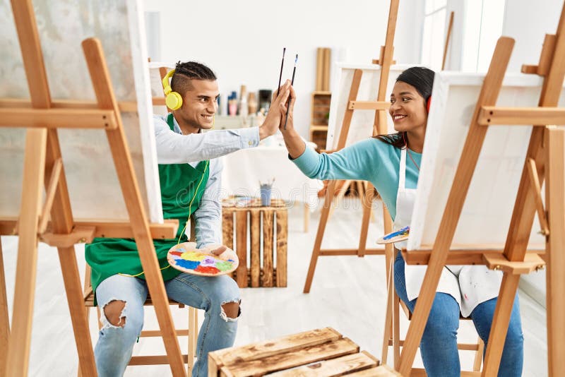 Young Latin Painter Couple High Five Painting and Using Headphones at ...