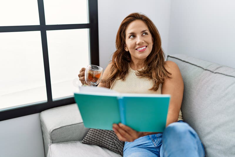 Young Latin Woman Drinking Tea and Reading Book at Home Stock Image ...