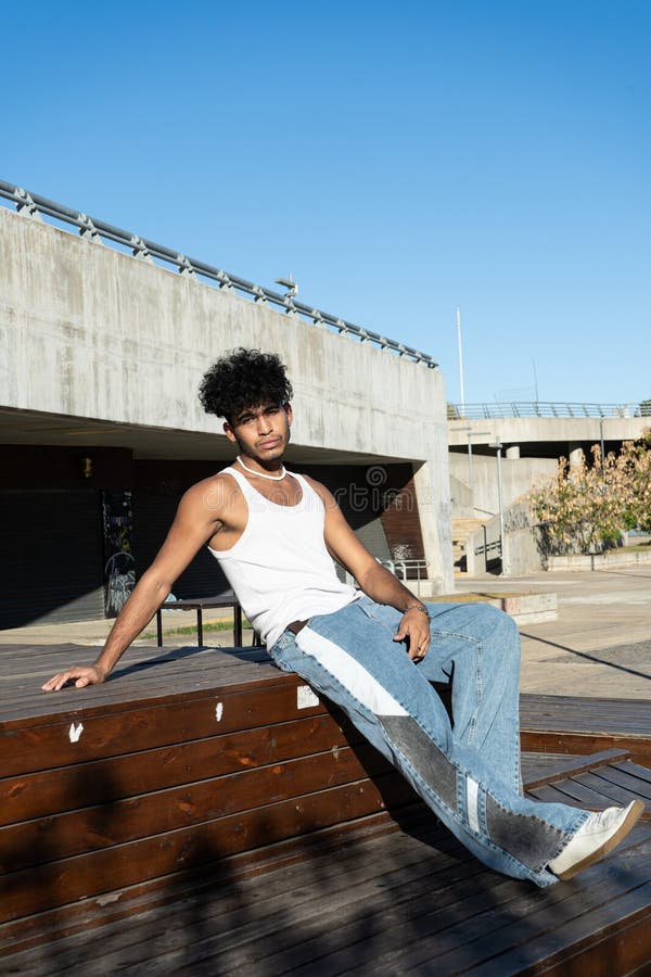 Young Latino Man Sitting on a Wooden Platform in a Square Stock Photo ...