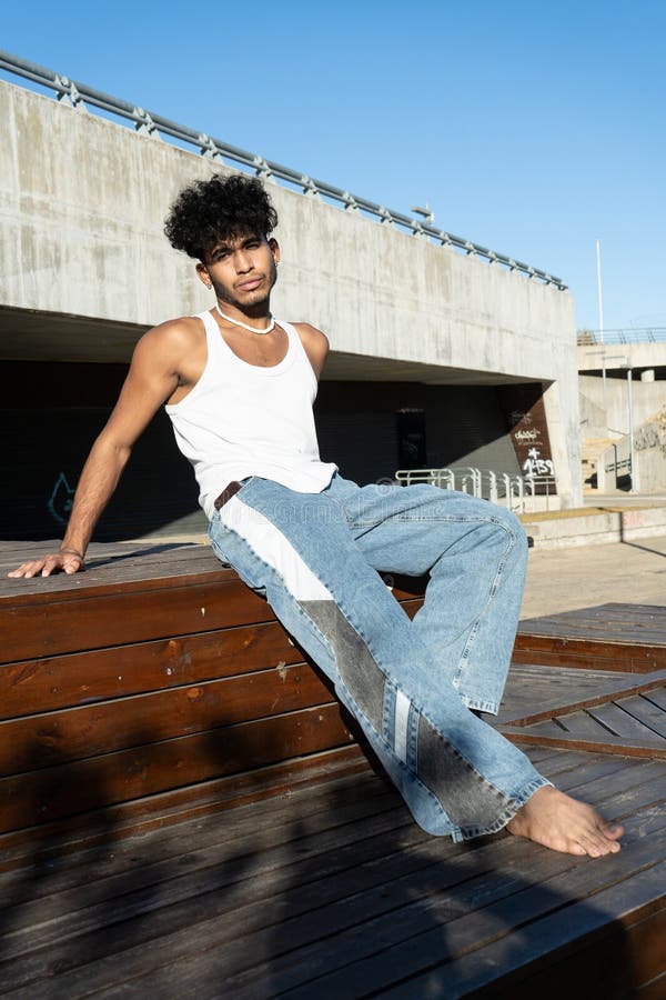 Young Latino Man Sitting on a Wooden Platform in a Square Stock Image ...