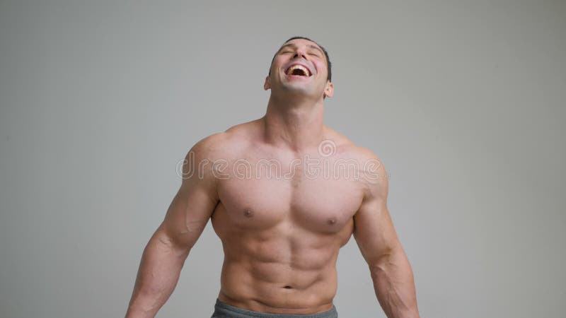 Young Laughing Muscular Bodybuilder Posing and Looking at Camera ...