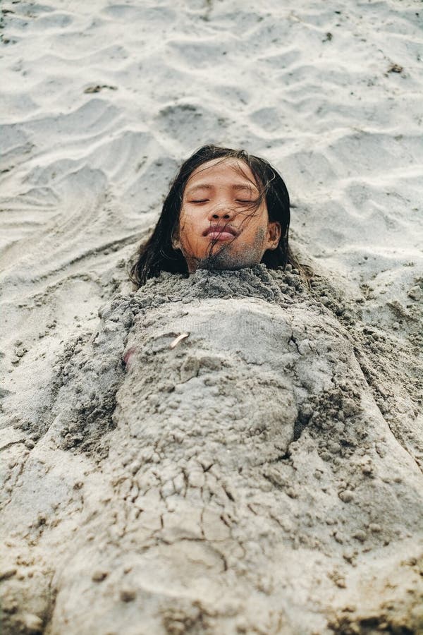 Young Little Girl Playing on the Beach Covered with the Sand Stock ...