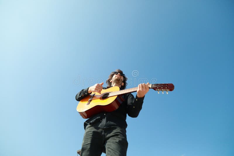 Young Long Hair Man Plays Classical Guitar Outside Low Angle Stock ...