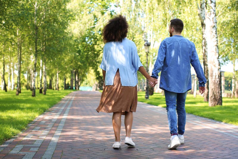 Young Loving Interracial Couple Walking in Park on Spring Day Stock ...