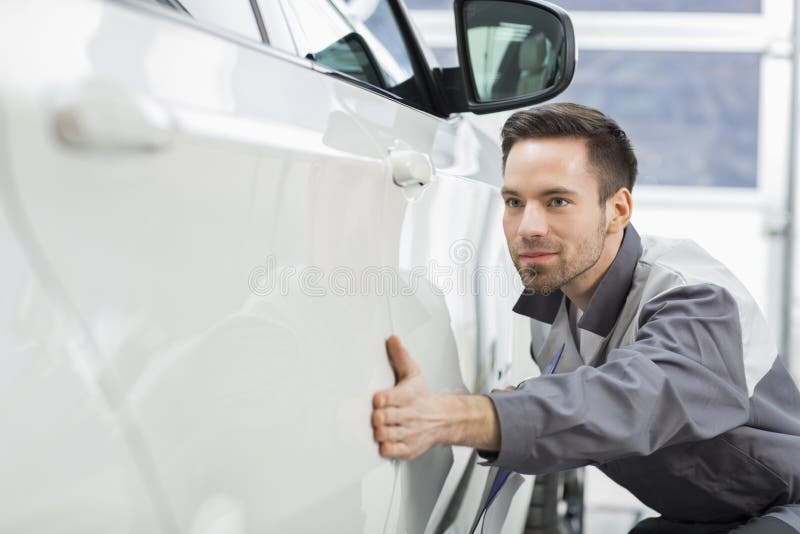 Young Maintenance Engineer Examining Car in Repair Shop Stock Photo ...