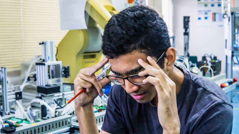 A Young Malay Engineering Student with Spectacles Thinking Hardly by ...