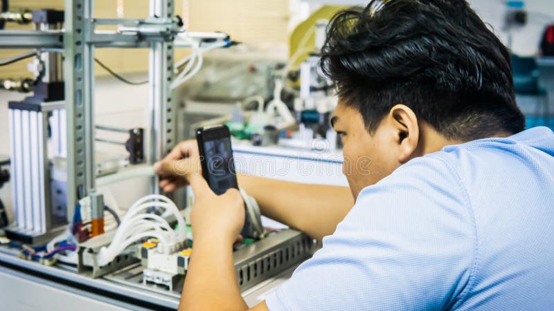 A Young Malay Engineering Student Working Using a Smartphone Taking ...
