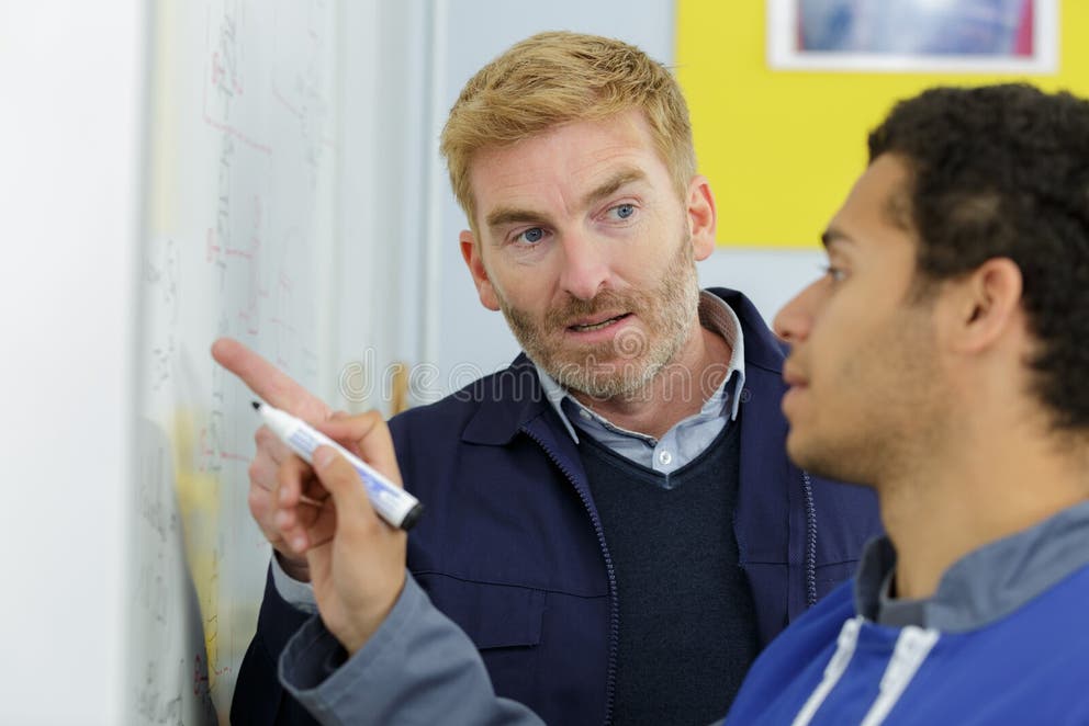 Young Male Apprentice Writing on Whiteboard Stock Photo - Image of ...