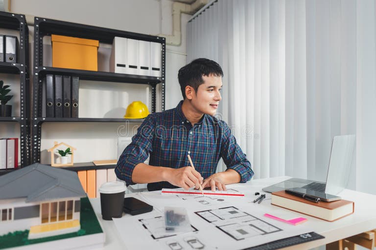 Young Male Architect Working at Office Desk, Drawing Construction Plans ...