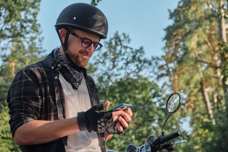 Young Male Biker in Helmet Using Mobile Phone and Smiling Sitting on a ...