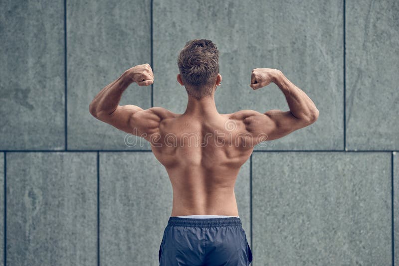 Young Male Bodybuilder Posing in Front of a Wall Stock Photo - Image of ...