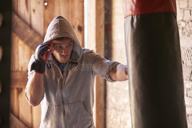 Young Male Boxer Working Out with Punchbag in Gym Stock Image - Image ...