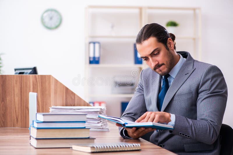 Young Male Businessman Reading Books at Workplace Stock Photo - Image ...