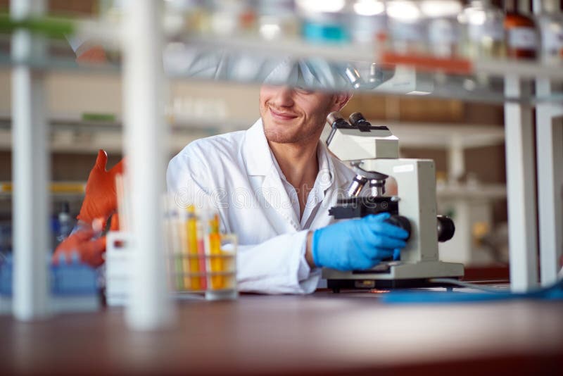 A Young Male Chemistry Student Enjoying Using a Microscope in a ...