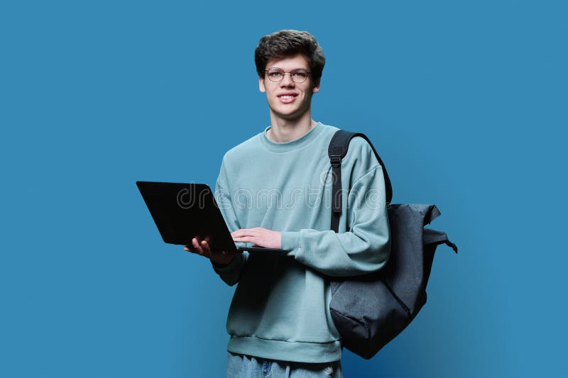 Young Male College Student Using Laptop, Blue Studio Background Stock ...