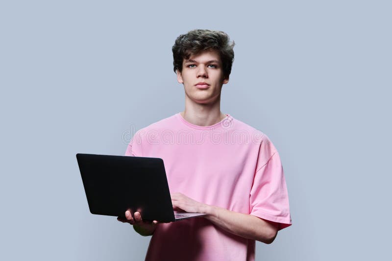Young Male College Student Using Laptop, Blue Studio Background Stock ...