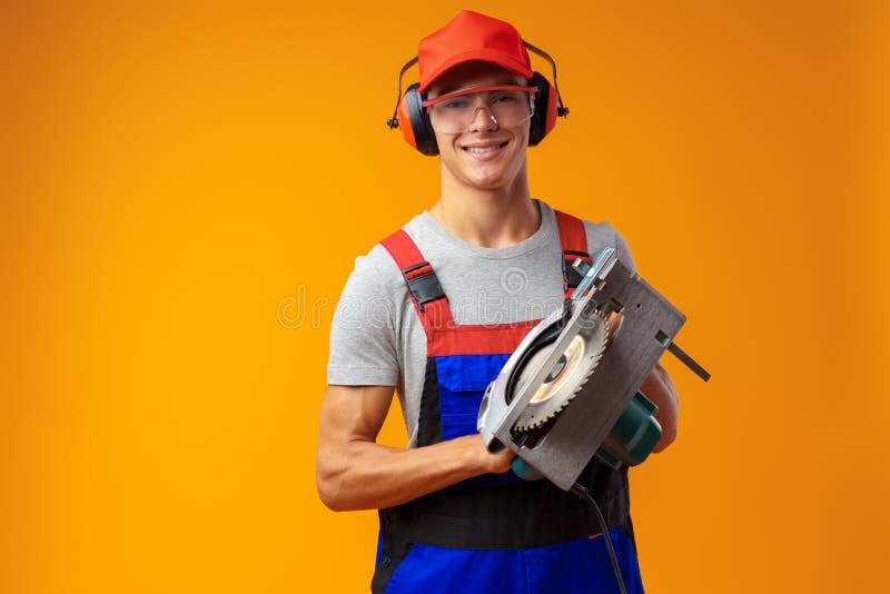 Young Male Construction Worker with Modern Circular Saw on Yellow ...