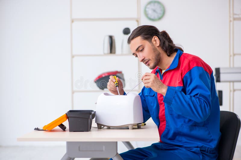 Young Male Contractor Repairing Toaster at Workshop Stock Image - Image ...
