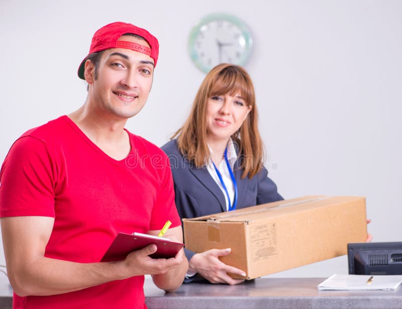 Young Male Courier Delivering Box To Hotel S Reception Stock Photo ...