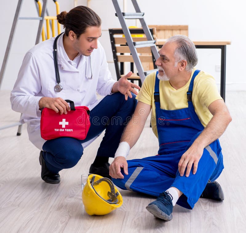 Young Male Doctor and Old Contractor in First Aid Concept Stock Image ...
