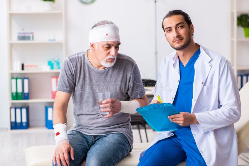 Young Male Doctor and Old Patient in First Aid Concept Stock Photo ...