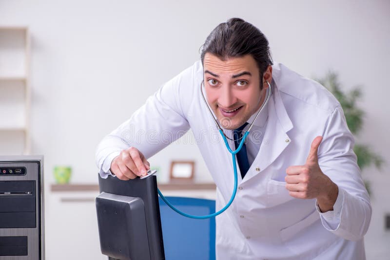 Young Male Doctor with Stethoscope Repairing Computer Stock Image ...