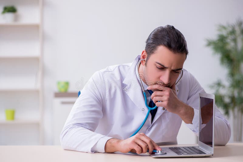 Young Male Doctor with Stethoscope Repairing Computer Stock Image ...