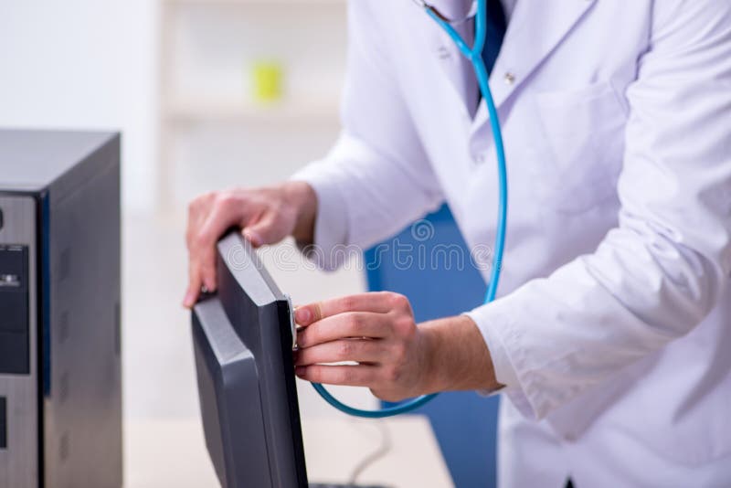 Young Male Doctor with Stethoscope Repairing Computer Stock Image ...