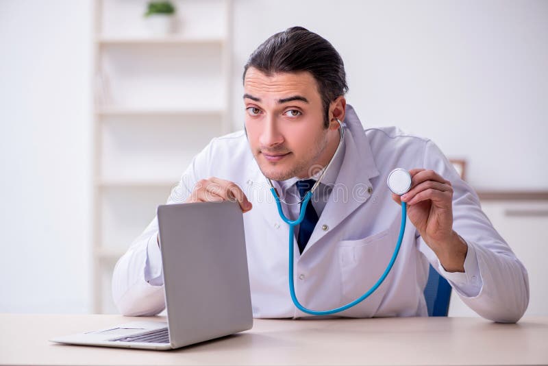 Young Male Doctor with Stethoscope Repairing Computer Stock Photo ...