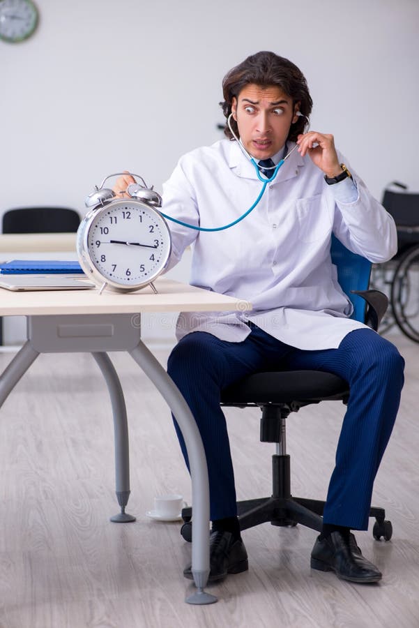 Young Male Doctor in Time Management Concept Stock Photo - Image of ...