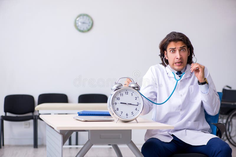 Young Male Doctor in Time Management Concept Stock Photo - Image of ...