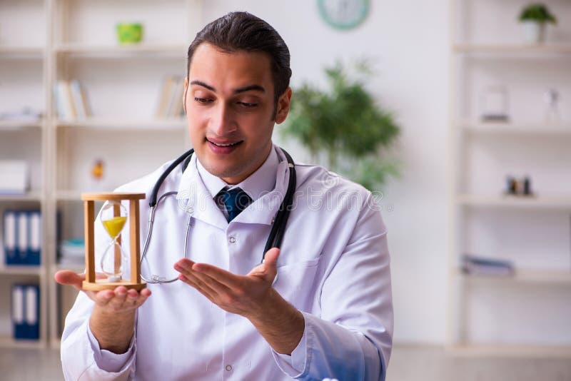 Young Male Doctor in Time Management Concept Stock Photo - Image of ...