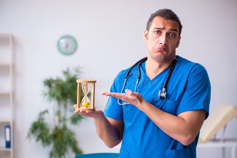 Young Male Doctor in Time Management Concept Stock Image - Image of ...