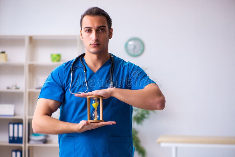 Young Male Doctor in Time Management Concept Stock Photo - Image of ...