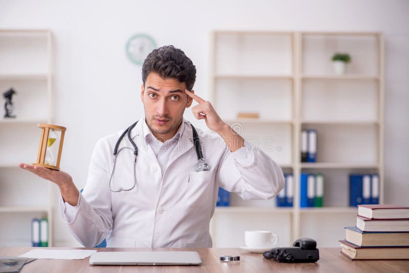 Young Male Doctor in Time Management Concept Stock Photo - Image of ...