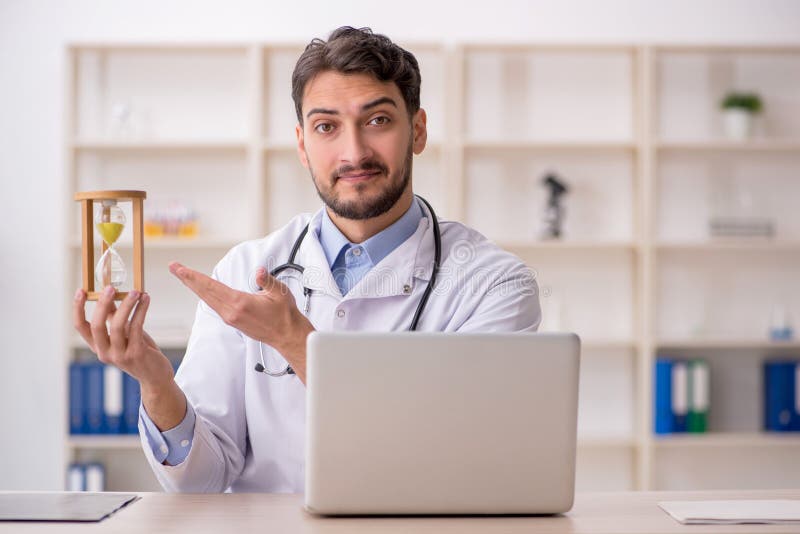 Young Male Doctor in Time Management Concept Stock Photo - Image of ...