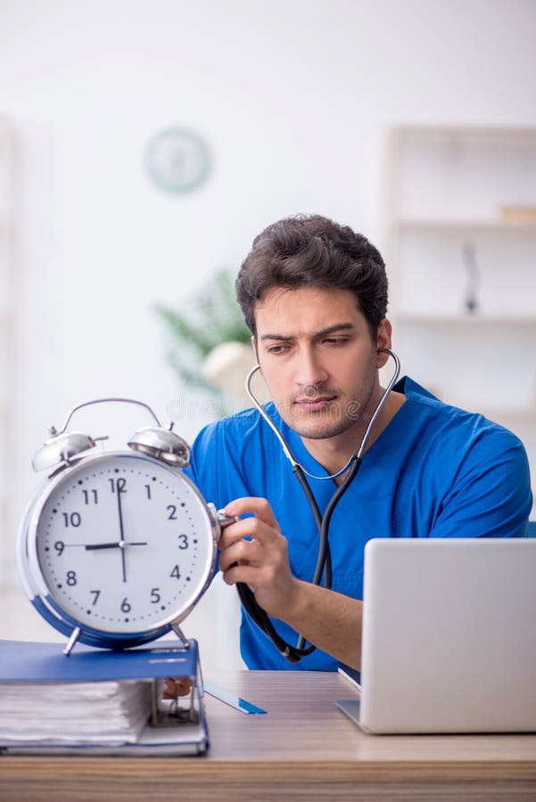 Young Male Doctor in Time Management Concept Stock Photo - Image of ...