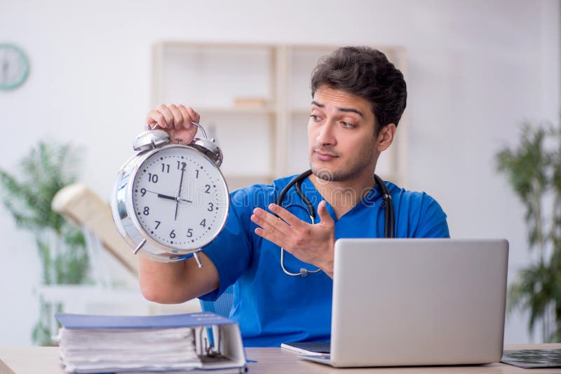Young Male Doctor in Time Management Concept Stock Image - Image of ...