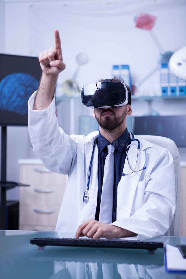 Young Male Doctor with Virtual Reality Headset Pointing Stock Photo ...