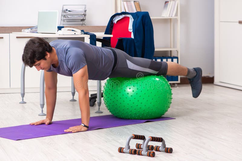The Young Male Employee Exercising in the Office Stock Image - Image of ...