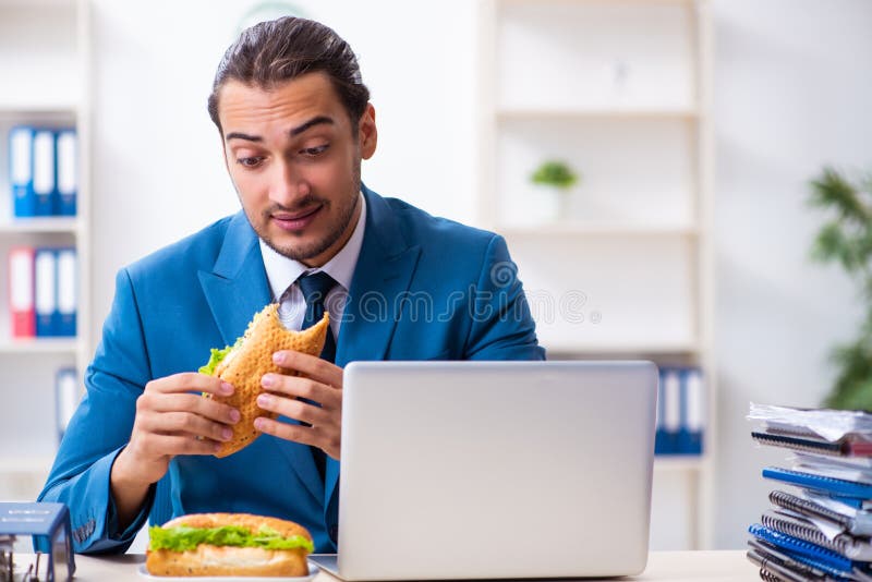Young Male Employee Having Breakfast at Workplace Stock Image - Image ...