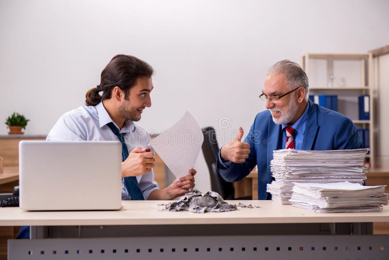 Young Male Employee and Old Boss Burning Papers at Workplace Stock ...