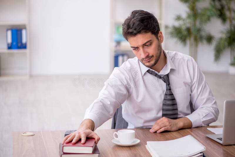 Young Male Employee Reading Book in the Office Stock Image - Image of ...