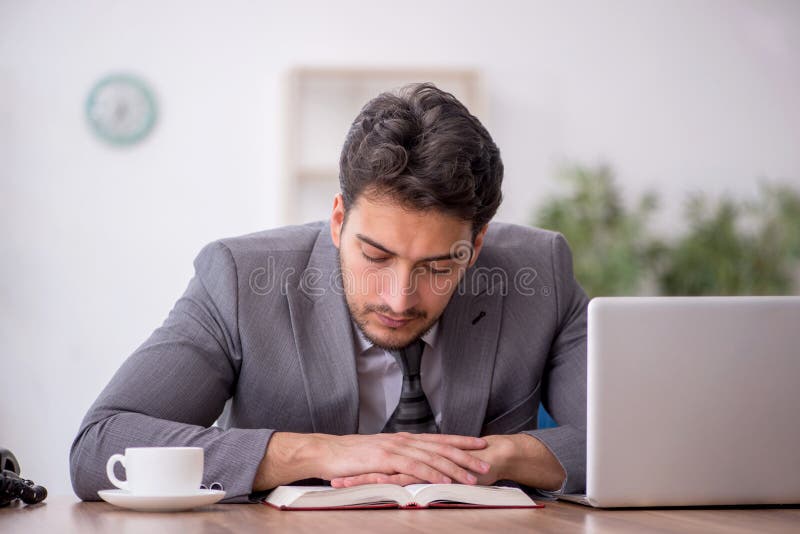 Young Male Employee Reading Book in the Office Stock Image - Image of ...
