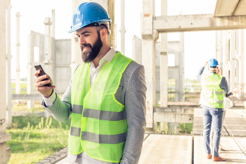Young Male Engineer or Businessman Using Smart Phone on a Construction ...
