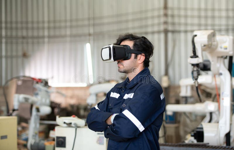 A Young Male Engineer Uses a VR Machine To Operate a Welding Robot. for ...