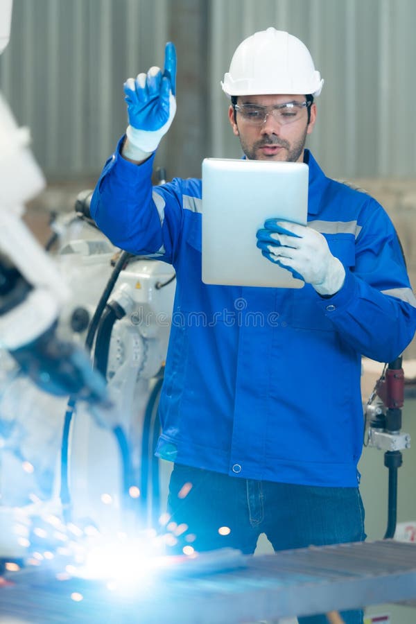Young Male Engineers are Manipulating a Welding Robot Hand. by ...