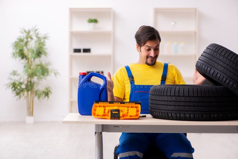 Young Male Garage Worker with Tyre at Workshop Stock Image - Image of ...